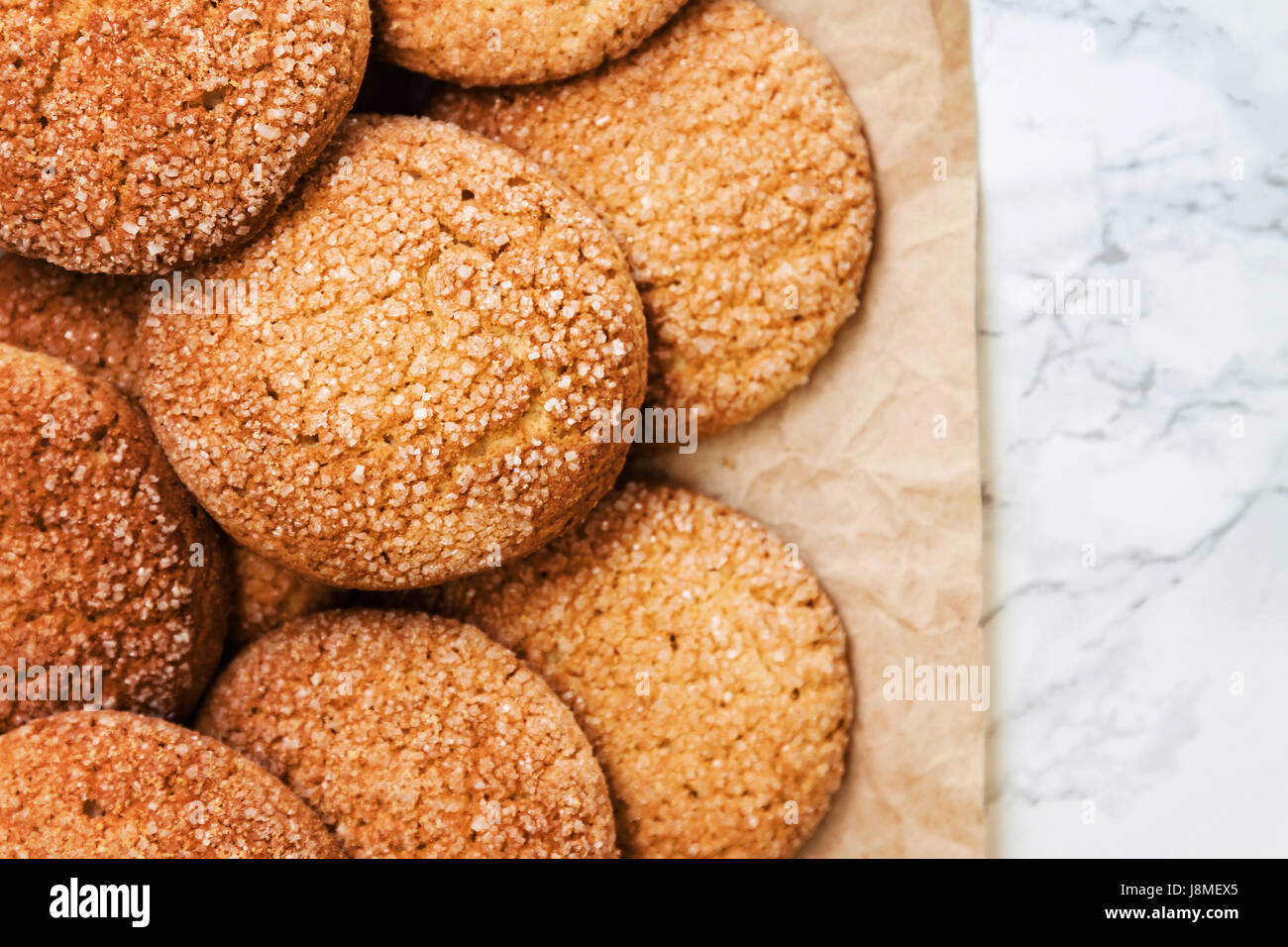 On a marble white table, sandy round cookies, one broken, top view ...