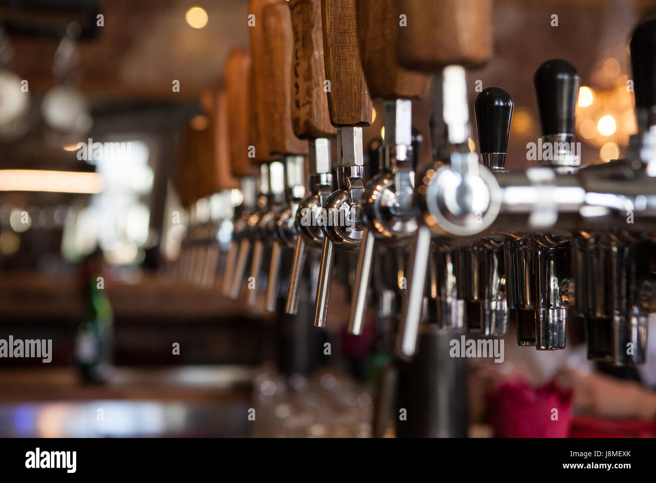 Lot of vintage Golden beer taps in the bar with the bartender in the ...