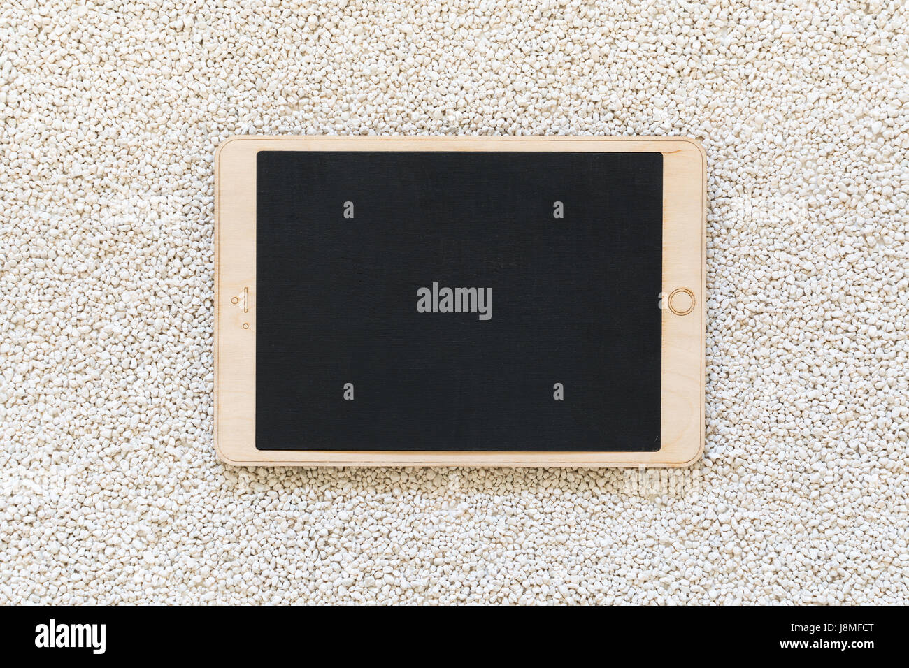 Tablet shaped chalk board on white pebbles background, flat lay Stock ...