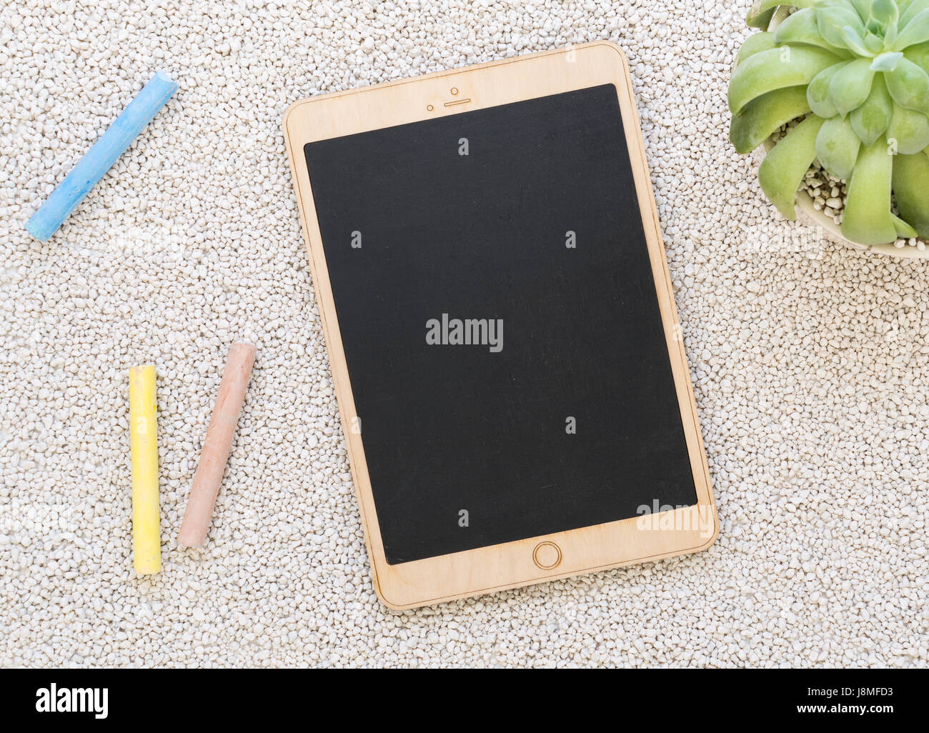 Tablet shaped chalk board on white pebbles background, flat lay Stock ...