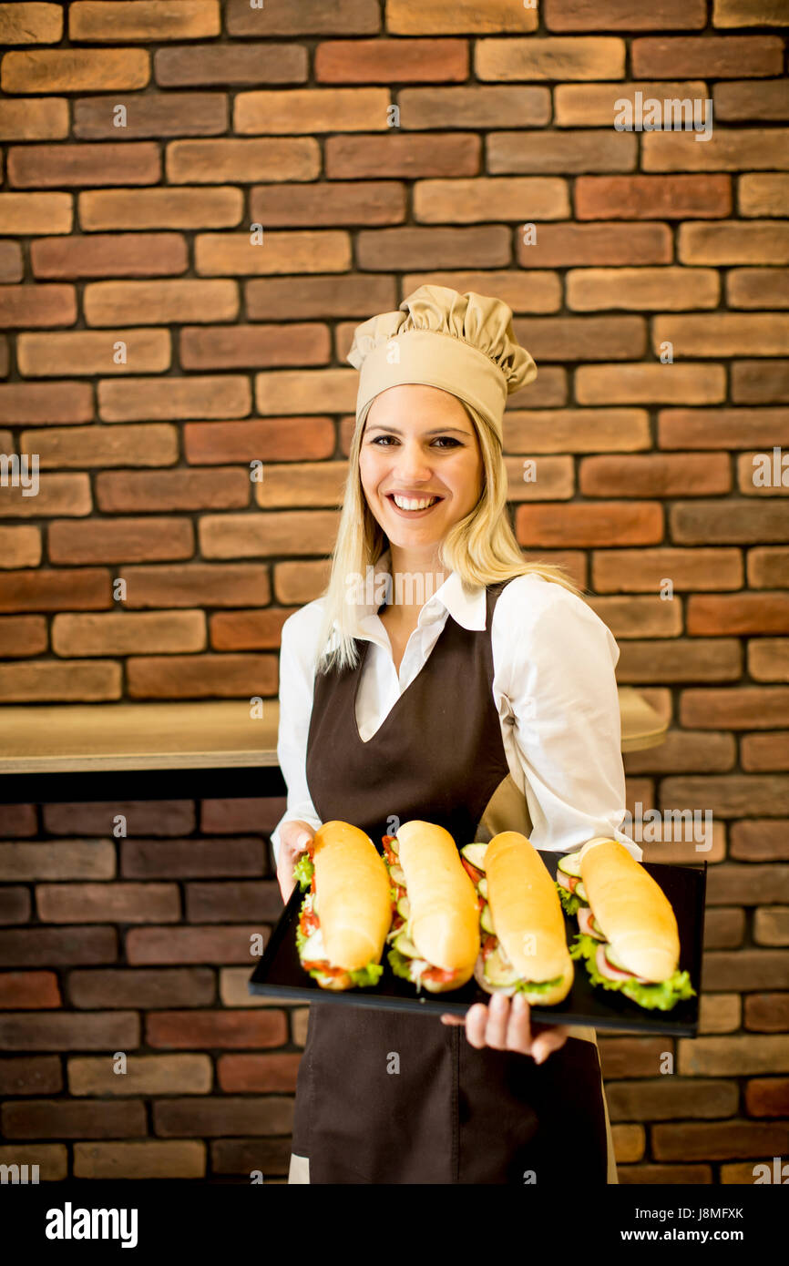 Beautiful female bakery posing with various types of sandwiches in the ...