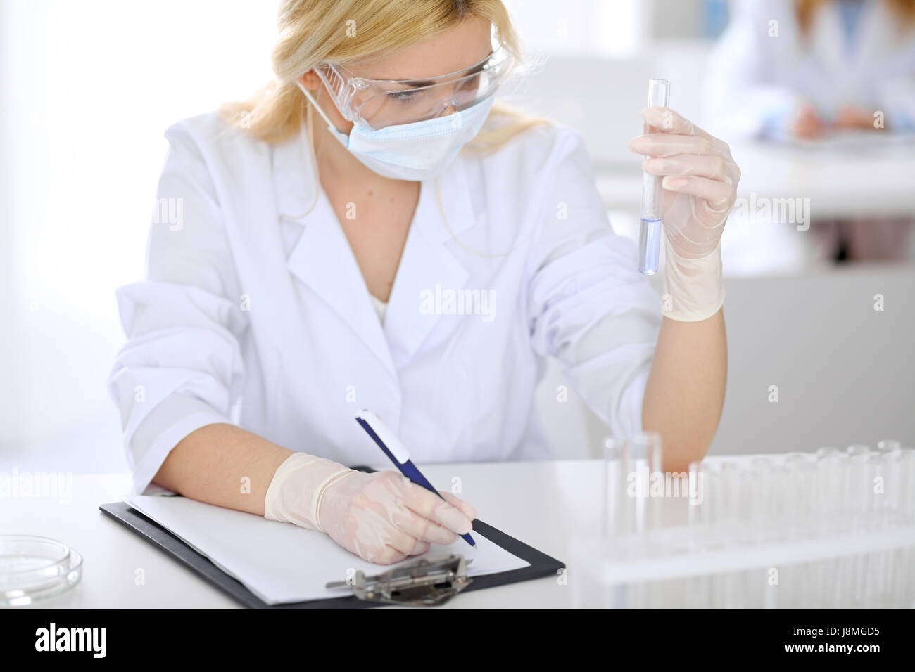 Female scientific research team with clear solution in laboratory Stock Photo - Alamy