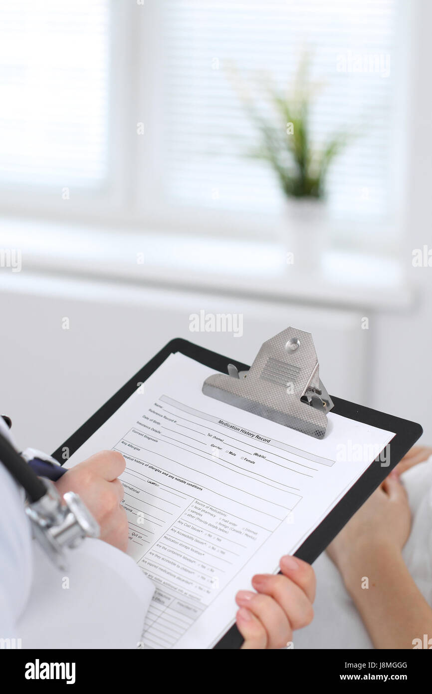 Close-up of a female doctor holding application form while consulting ...