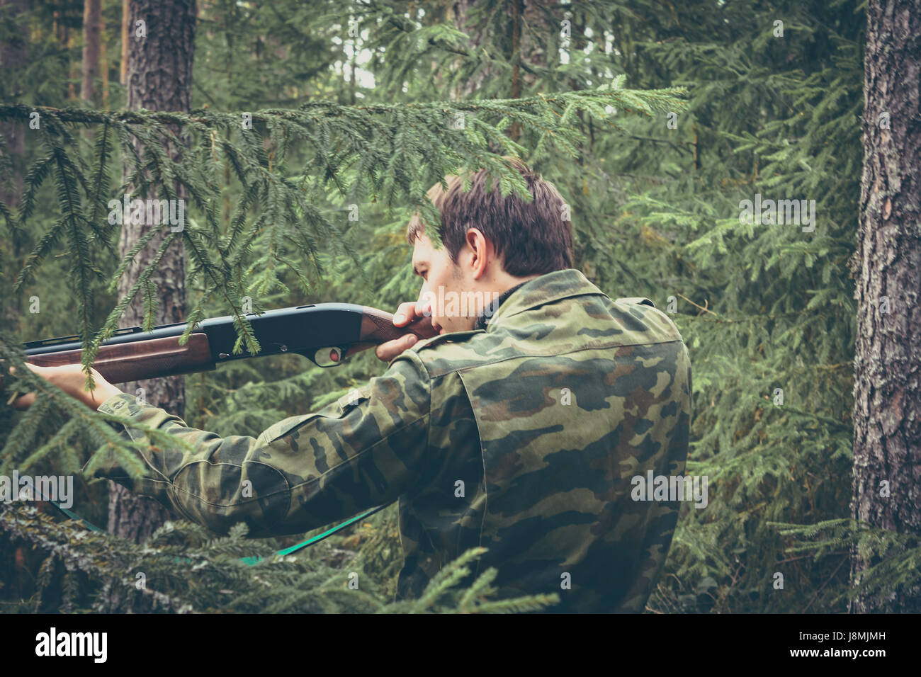 Hunter in forest during hunting season aiming before shoot Stock Photo ...