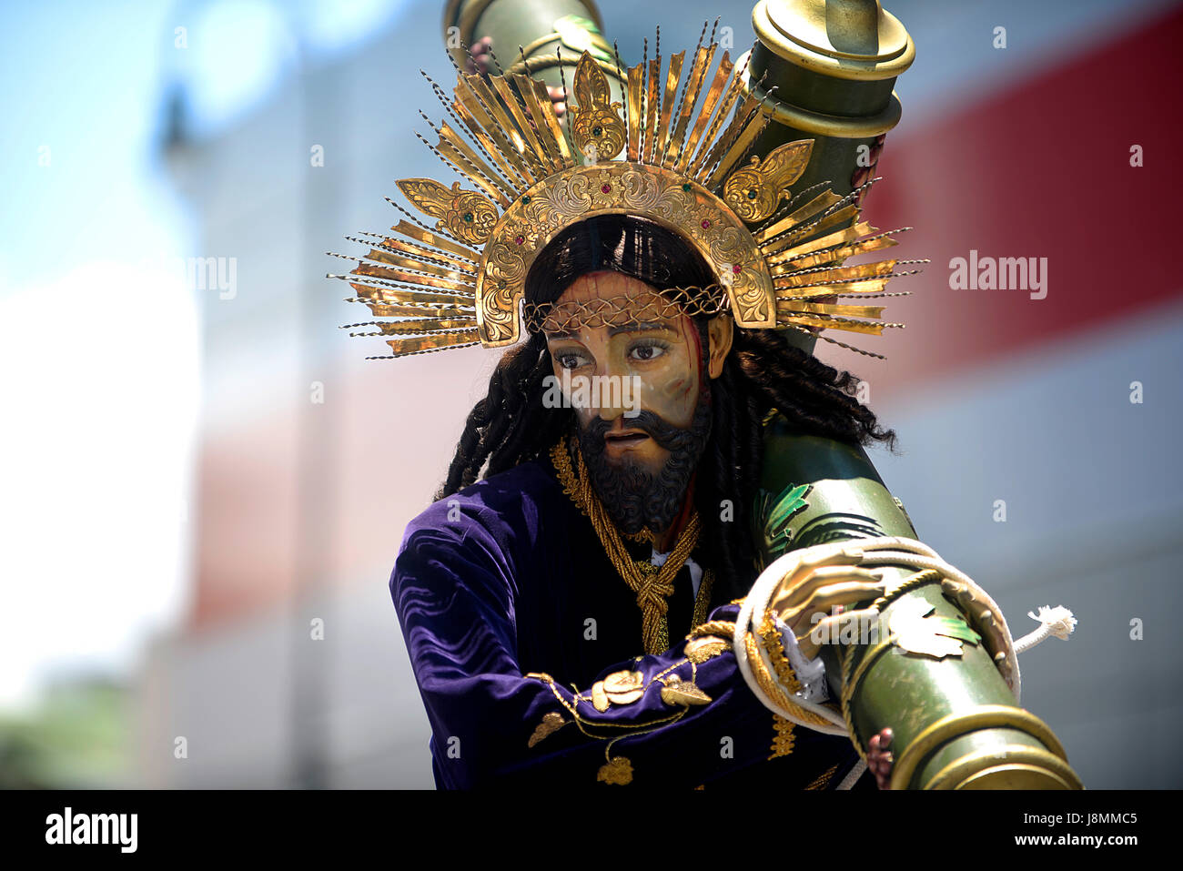A statue of Jesus Christ carrying the cross is marched down the street ...