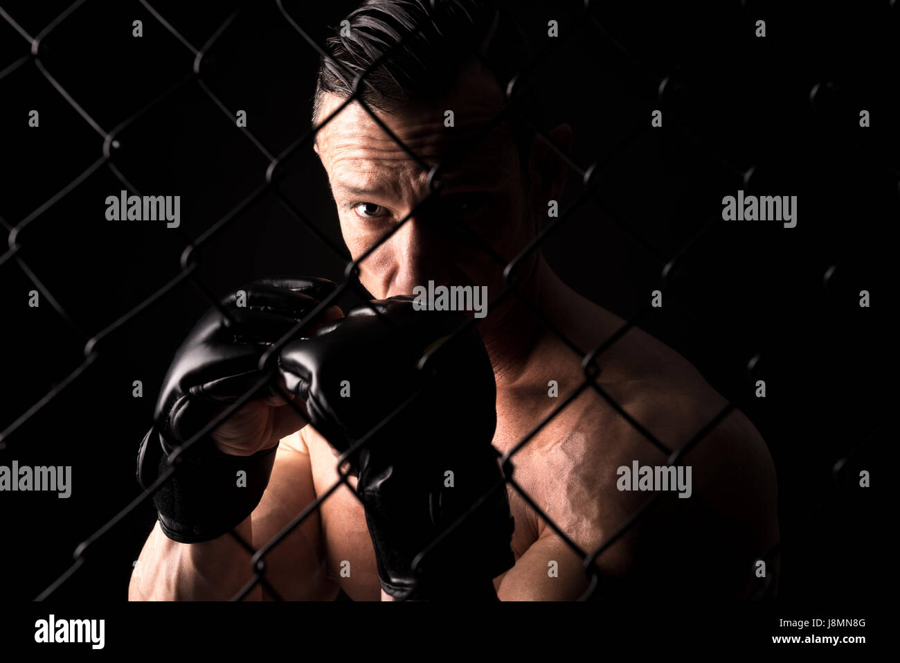Strong Mixed Martial Arts fighter inside the cage Stock Photo - Alamy