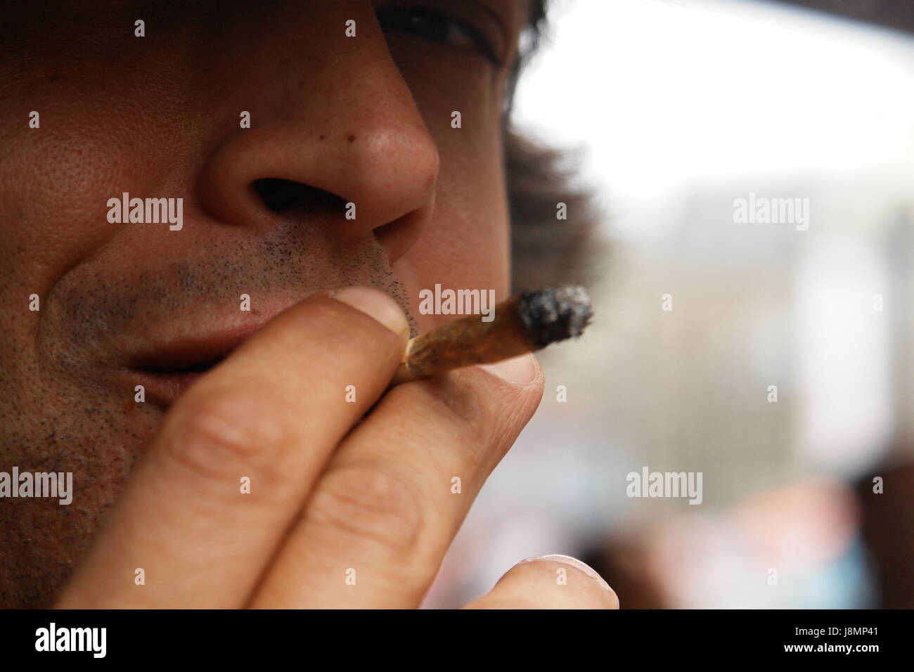 Close-up of man smoking marijuana joint Stock Photo - Alamy