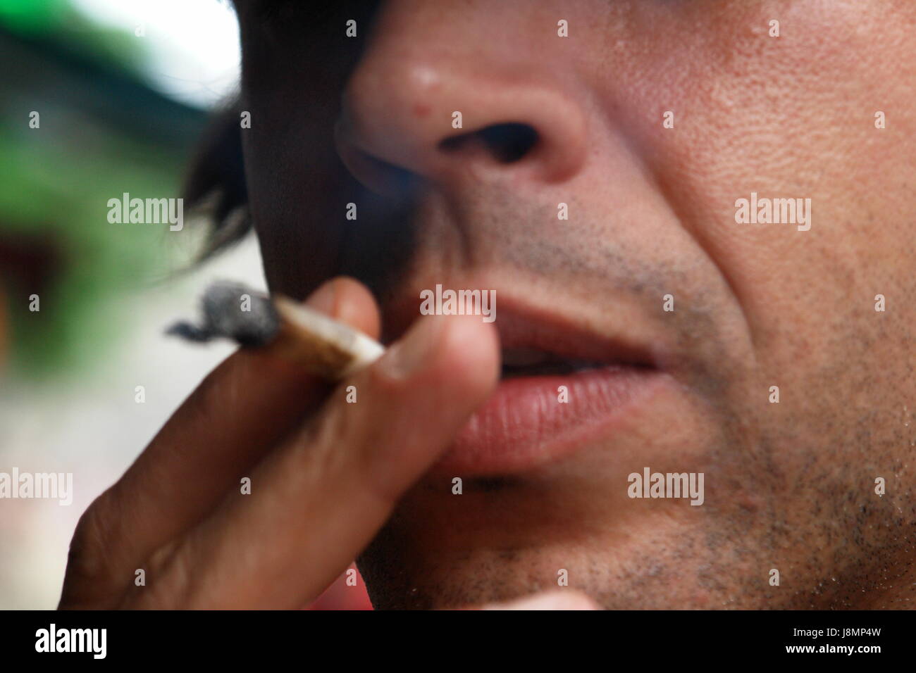 Close-up of man smoking marijuana joint Stock Photo - Alamy