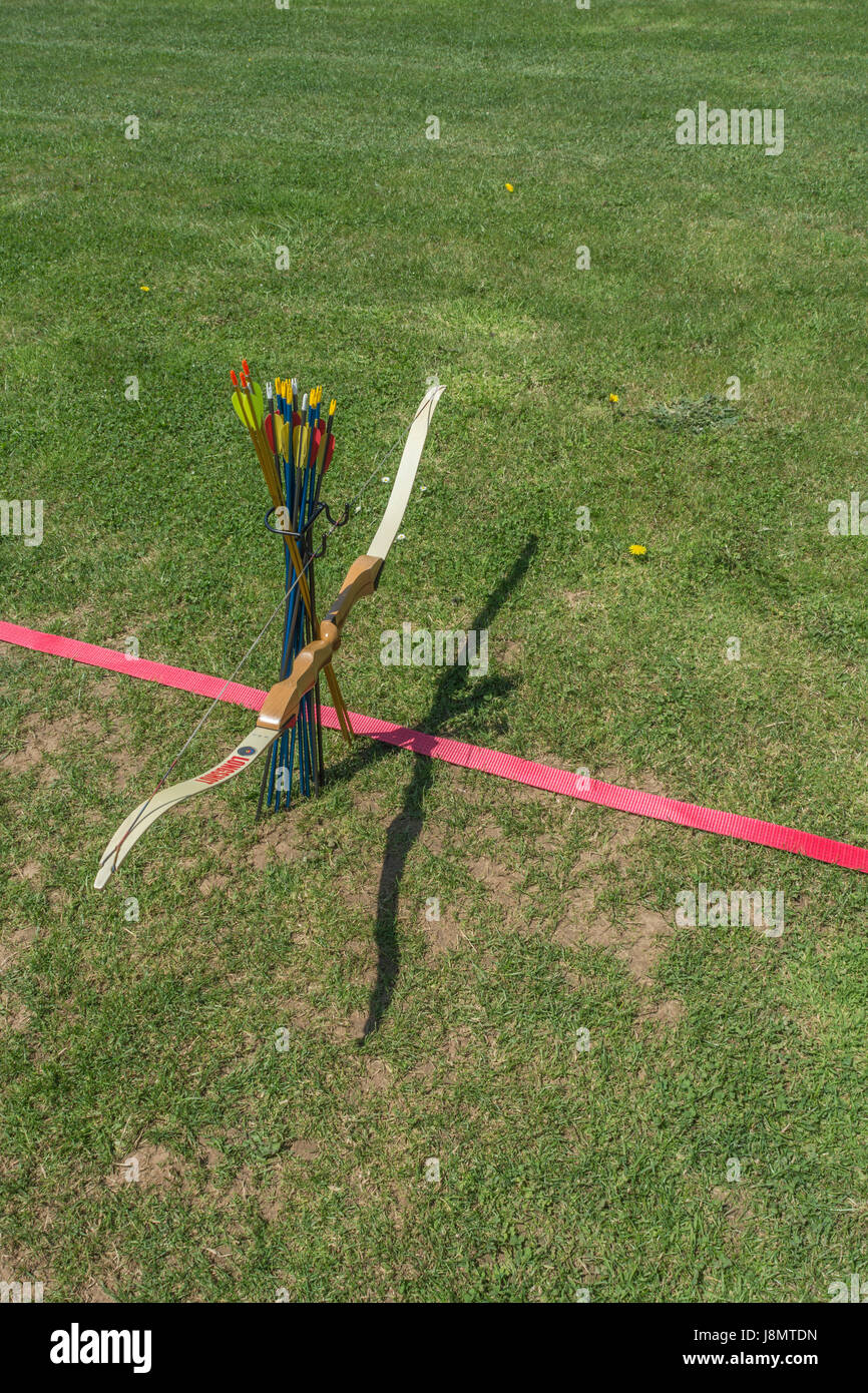 Sports target bow and arrows at the standing line on an archery range ...