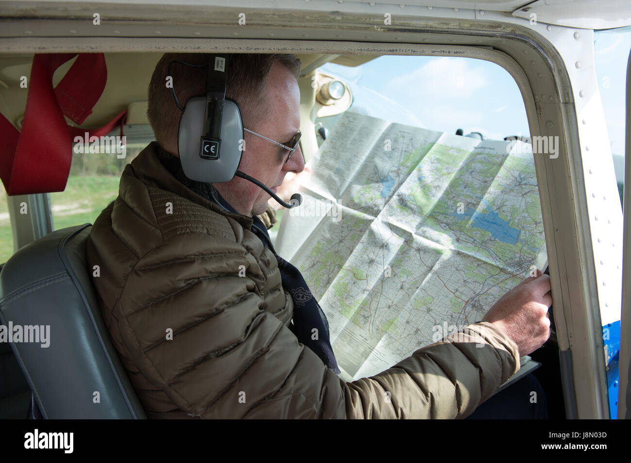 Aerial observer Michael Muenchow looks at a map in a Cessna 172 during ...