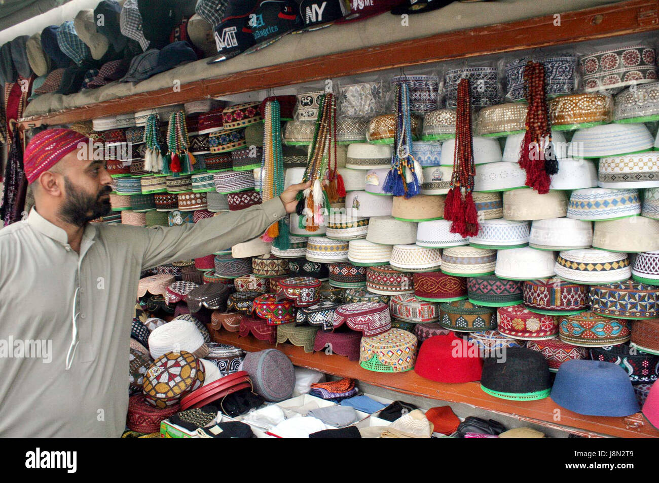 Faithful Muslims busy to buy prayer beads and prayer caps at a roadside ...