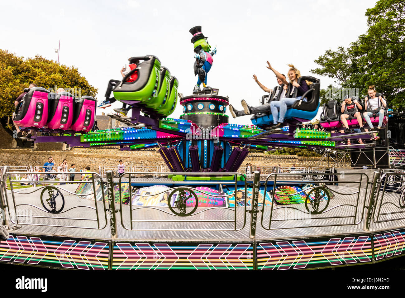 Traditional carousel ride at British funfair. Eight arms of three seat ...