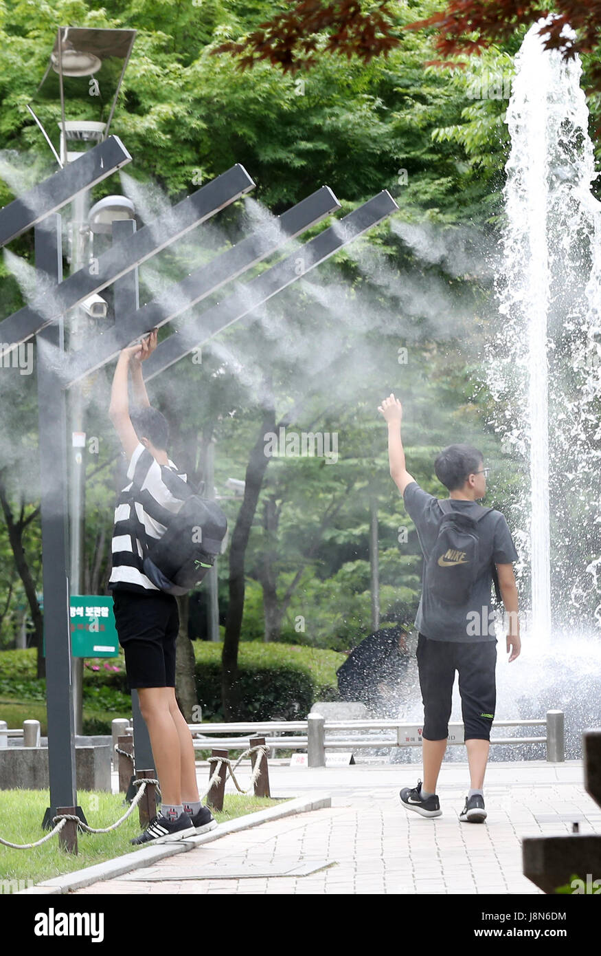 Cooling fog system in park Children stand under a cooling fog system ...