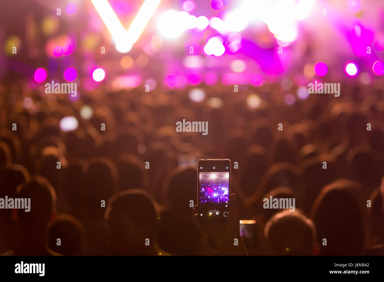 Hand with a smartphone records live music festival, Taking photo of ...