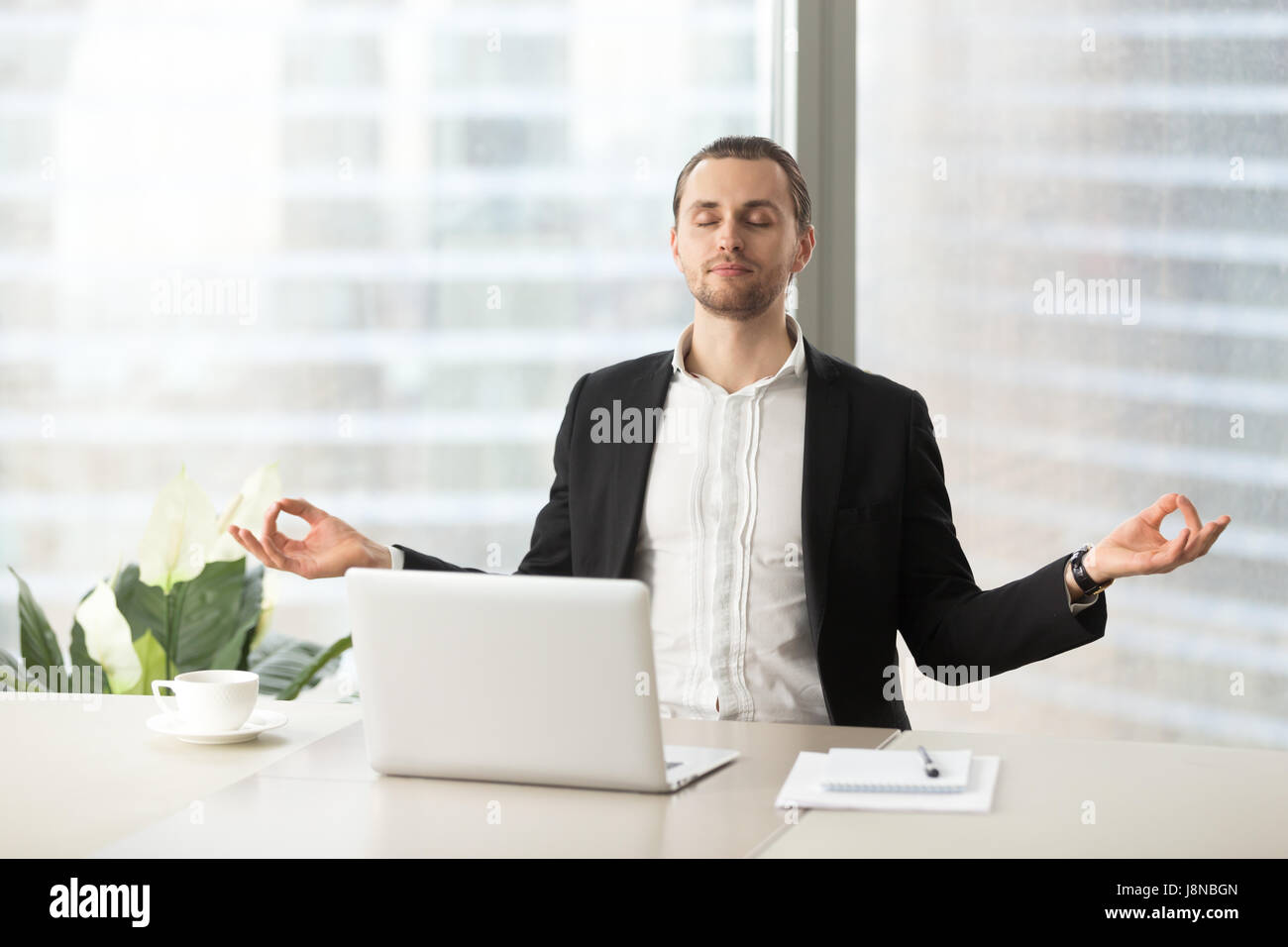 Relaxed corporate man sitting with closed eyes contemplating at work ...