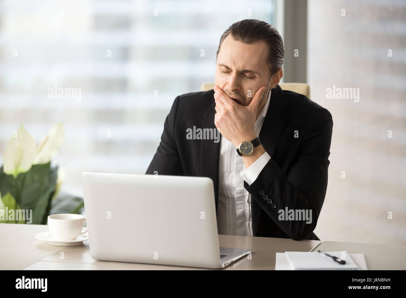 Businessman struggling with drowsiness at work Stock Photo - Alamy