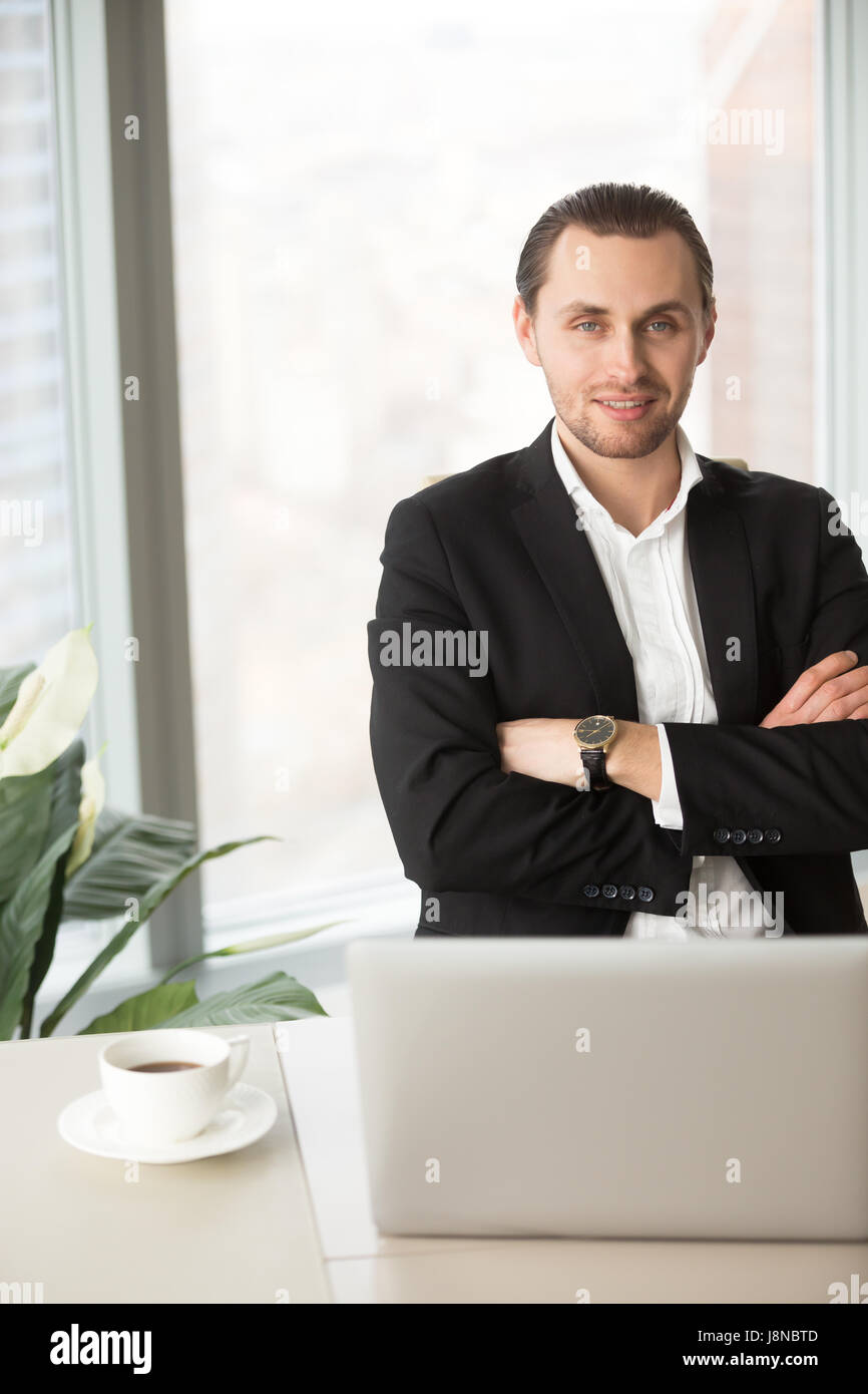 Portrait of CEO sitting at desk with arms crossed Stock Photo - Alamy