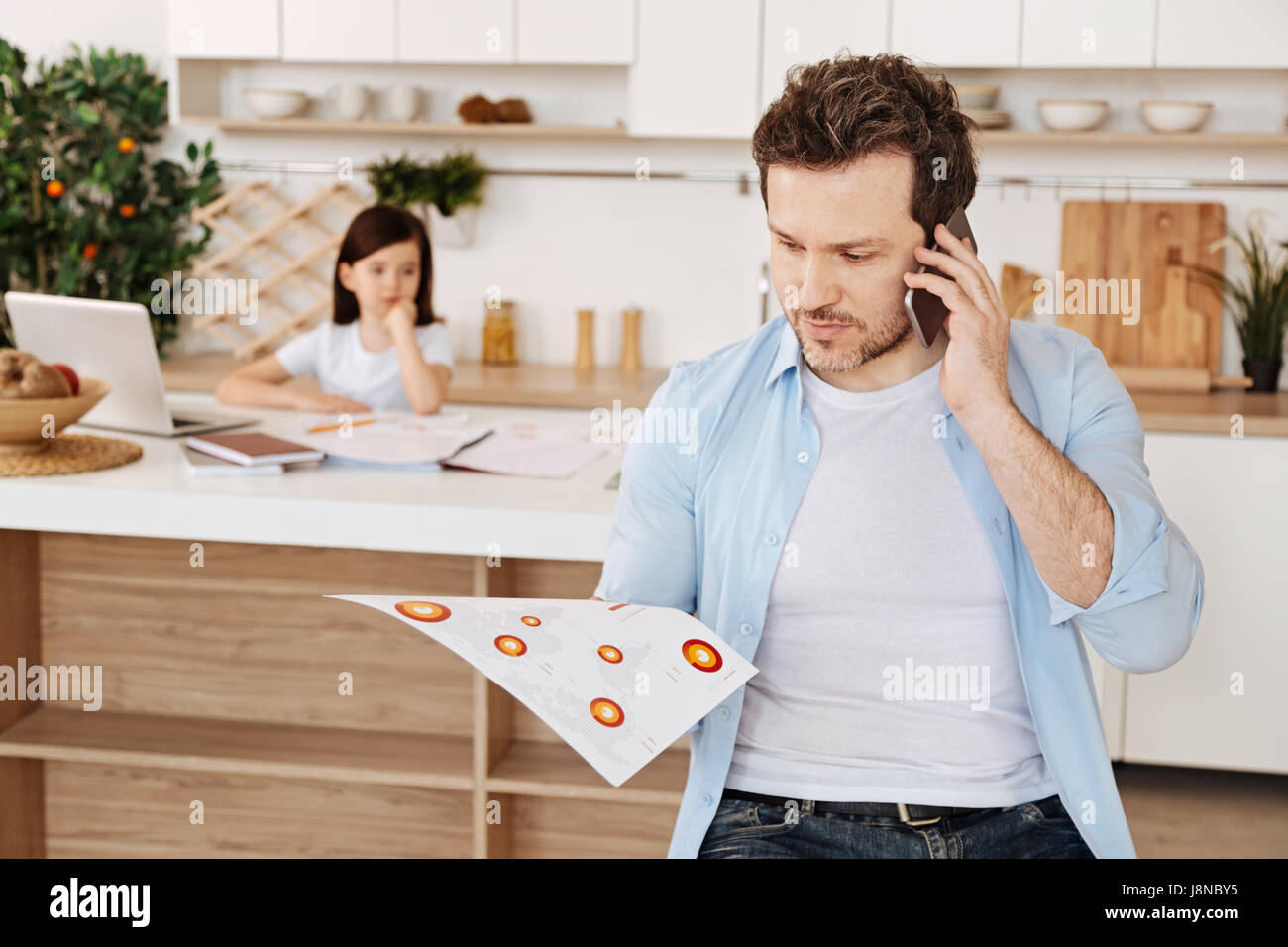 Swamped up with work. Pleasant young bristled father talking on the ...