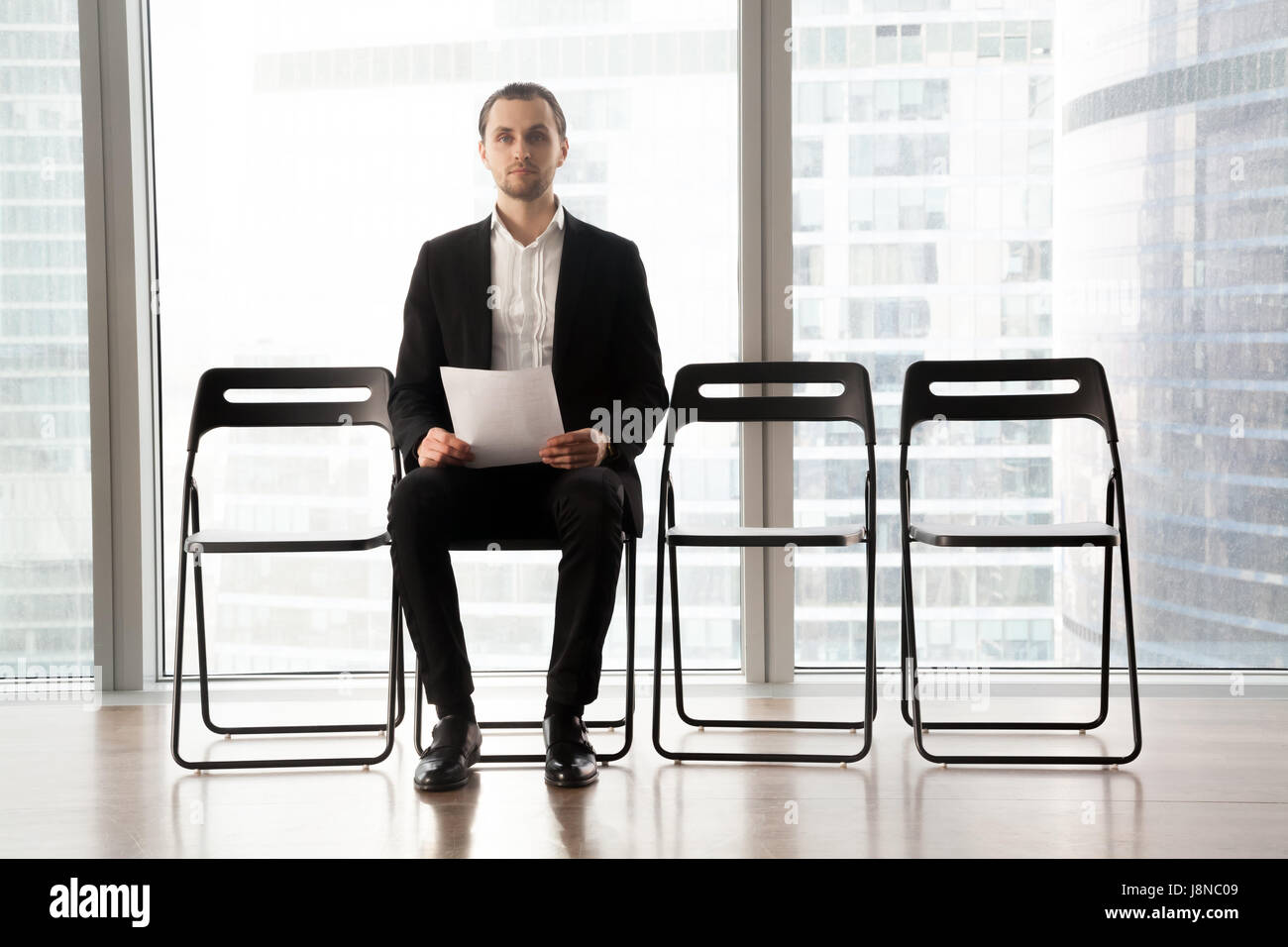 Candidate on post sitting on chair with resume Stock Photo - Alamy