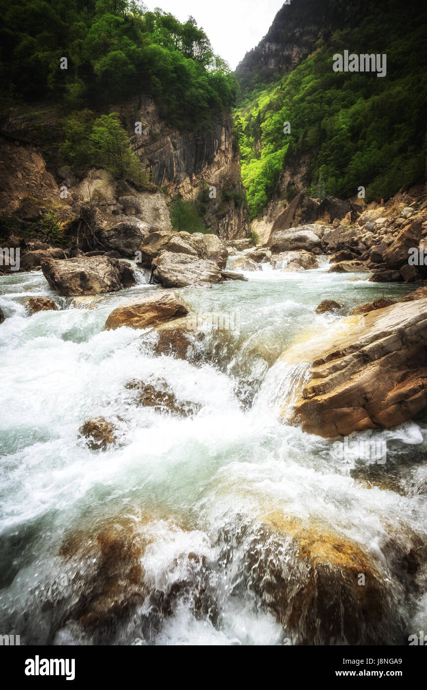 Mountain landscape in Ingushetiya. Powerful stream goes down from hills ...