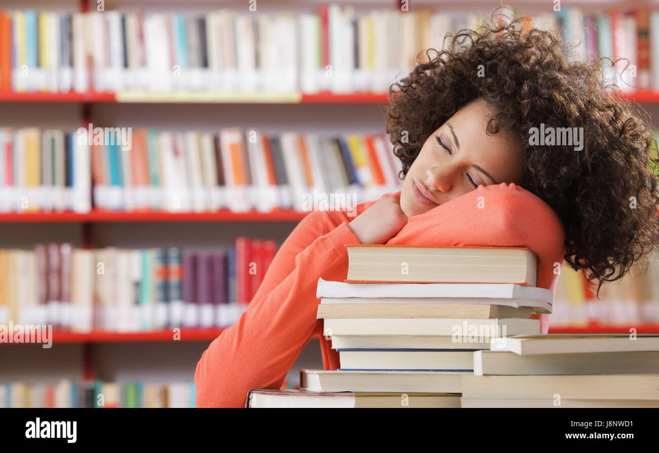 Student sleeping on desk in the library Stock Photo - Alamy