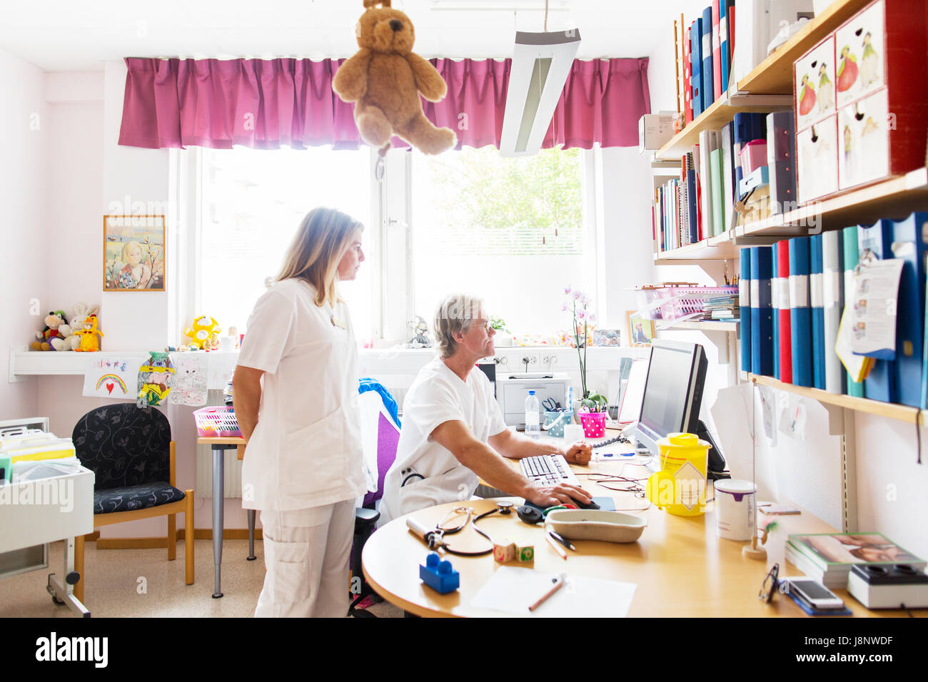 Doctor and nurse looking at computer monitor Stock Photo - Alamy