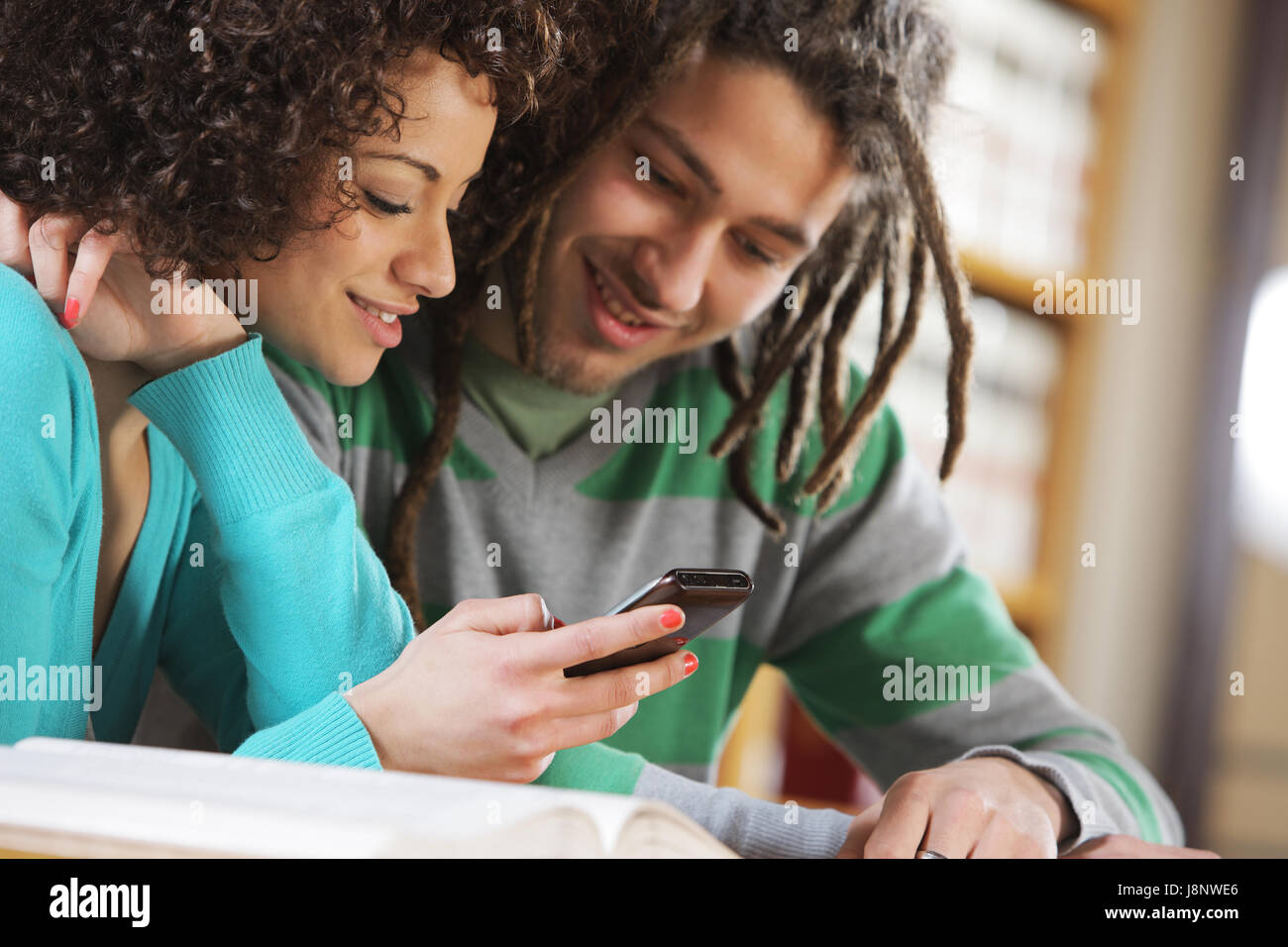 Two students looking at their mobile phones Stock Photo - Alamy