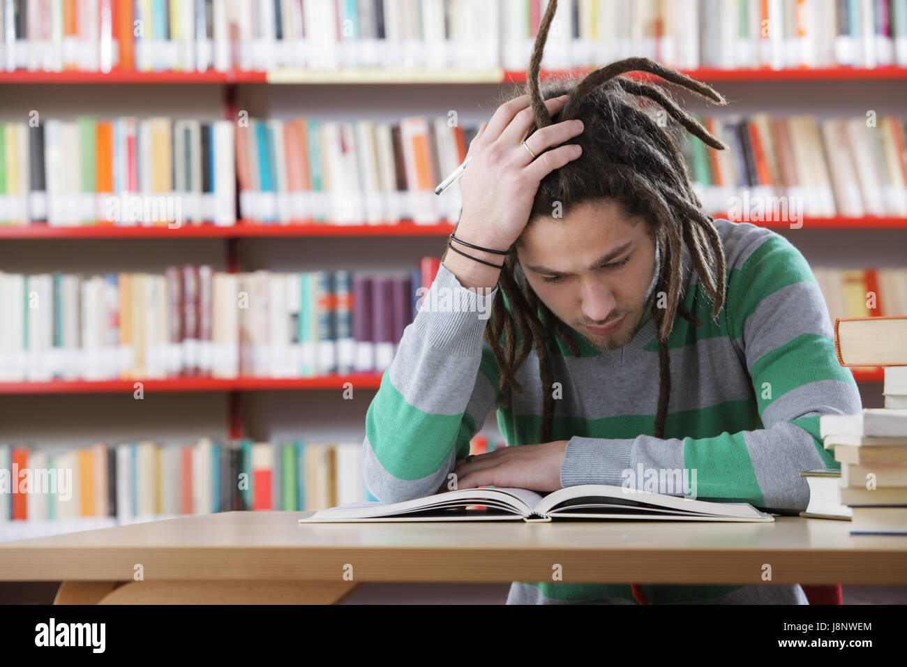 Student sitting in the library and working hardly Stock Photo - Alamy