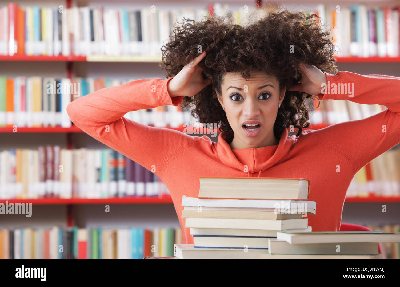 Portrait of stressed female student in library Stock Photo - Alamy