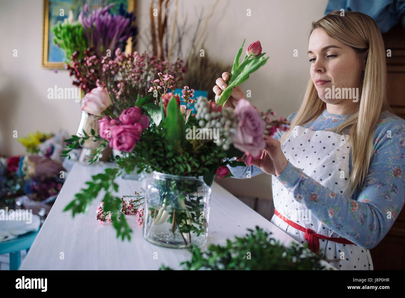 woman florist making bouquet of flowers indoor. Female florist ...