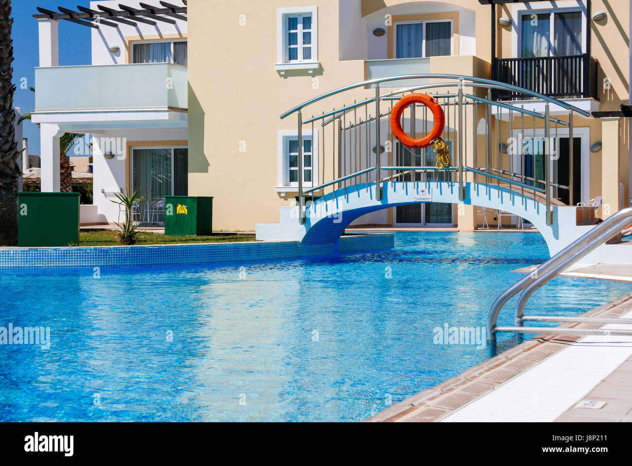 Hotel outdoor swimming pool with clear water and foothbridge Stock ...