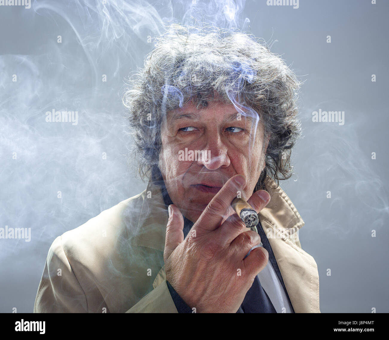 The senior man with cigar as detective or boss of mafia on gray studio ...