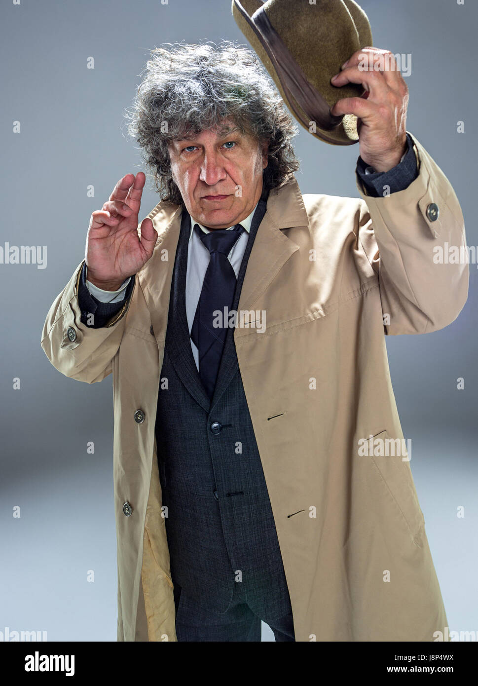 The senior man as detective or boss of mafia on gray studio background ...