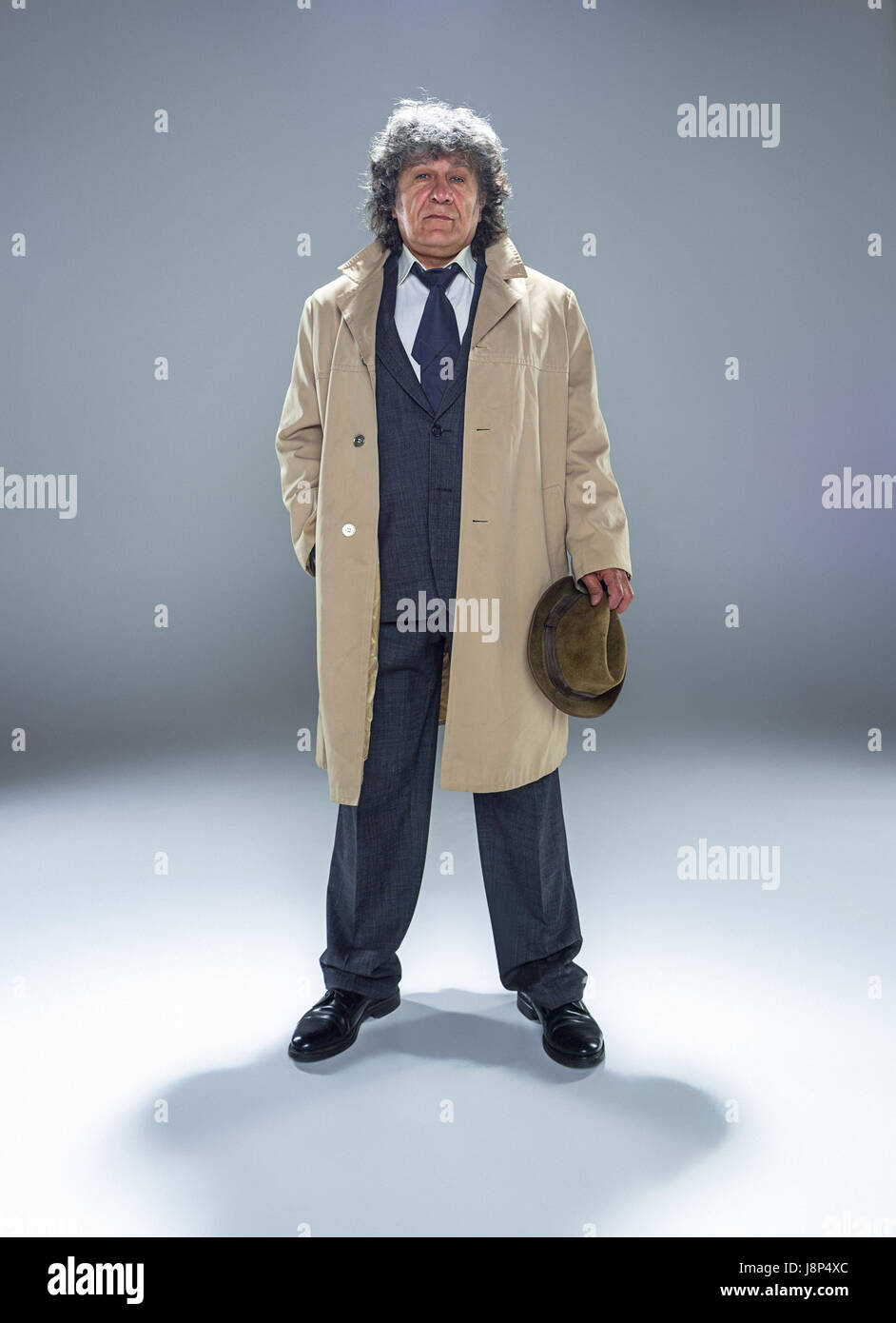 The senior man as detective or boss of mafia on gray studio background ...