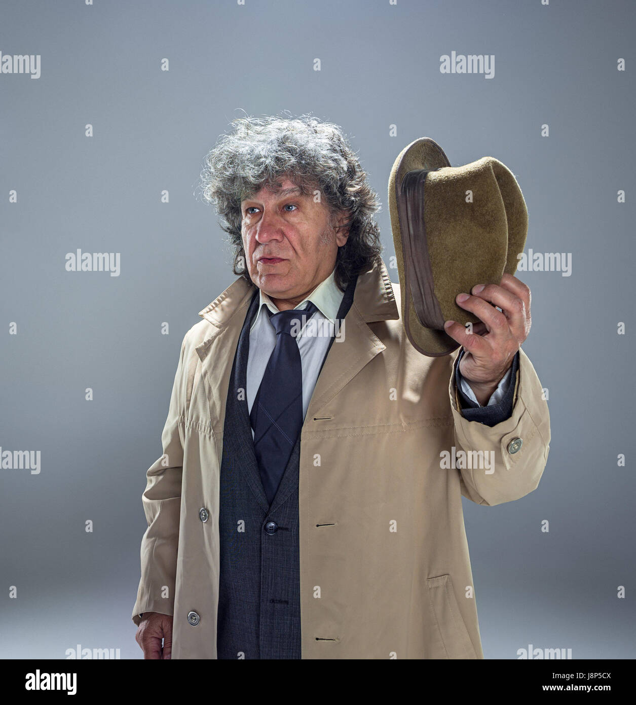The senior man as detective or boss of mafia on gray studio background ...
