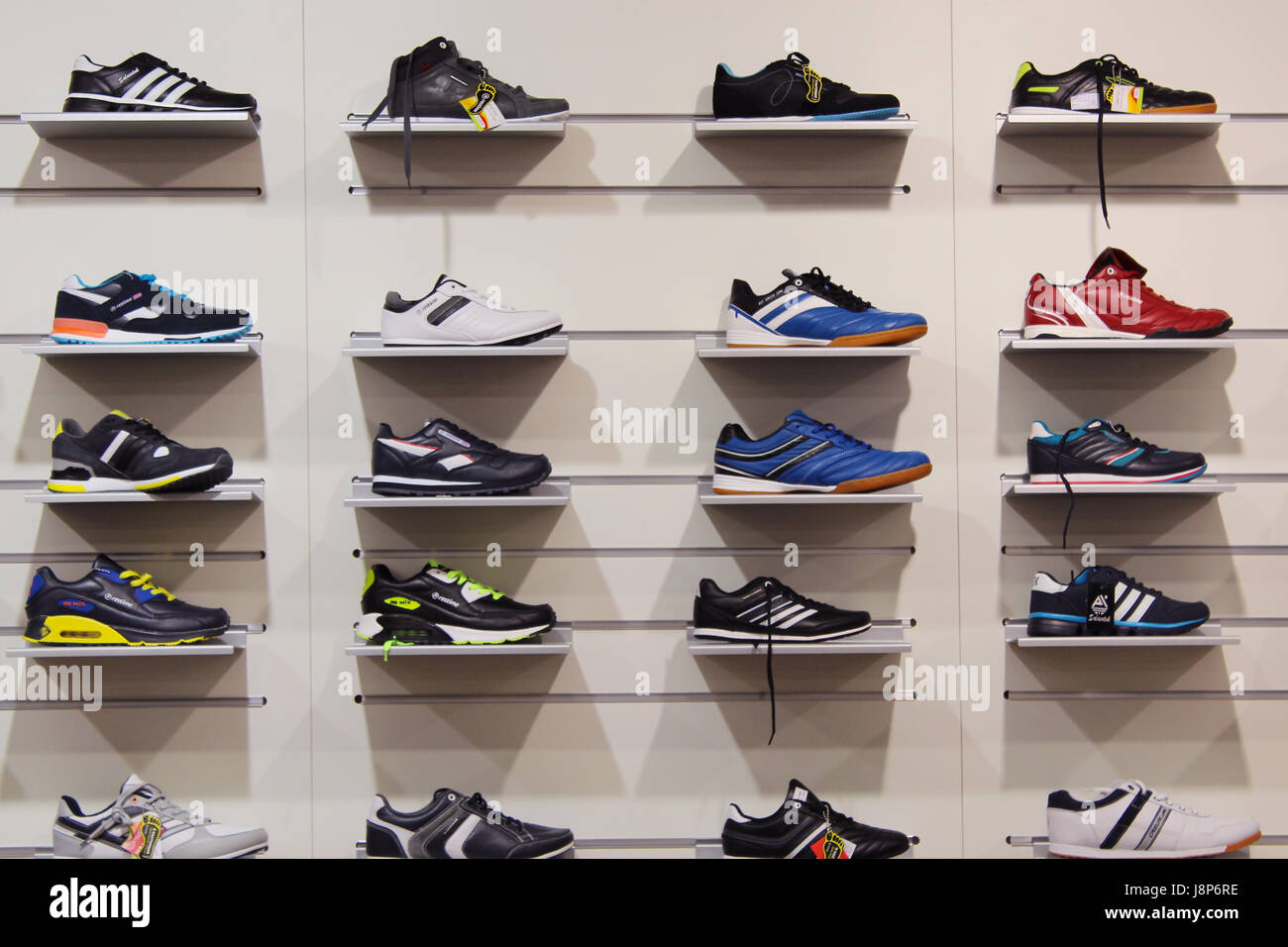 Sneakers on the shelves in the shop. Big assortment of sport footwear ...