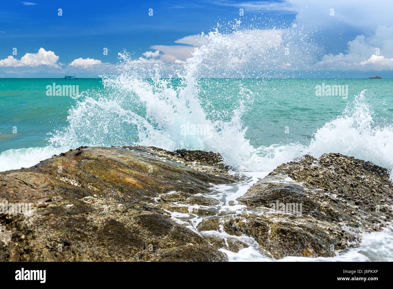 Splash water of sea wave attack to the rock phot with outdoor sunny ...