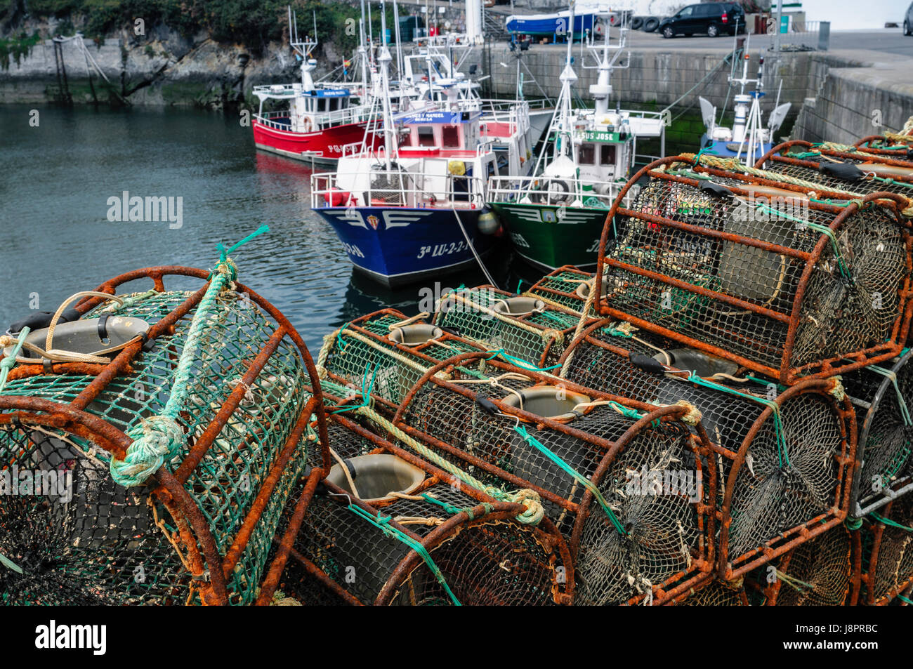 Lobster pots in a port on the coast of Asturias with fishing boats in ...