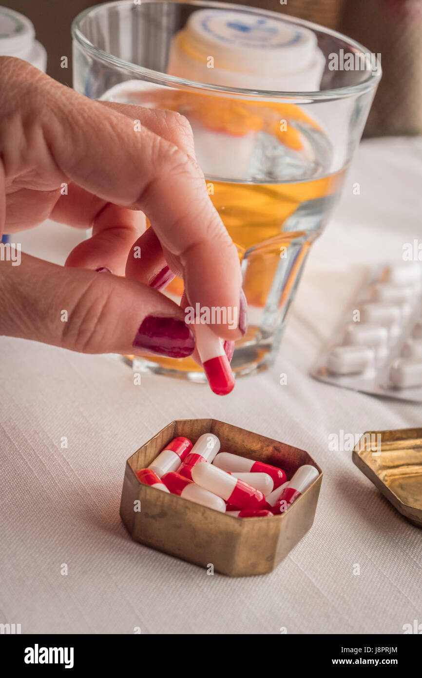 Hand women take capsules red and white in a pillbox metalic old Stock ...