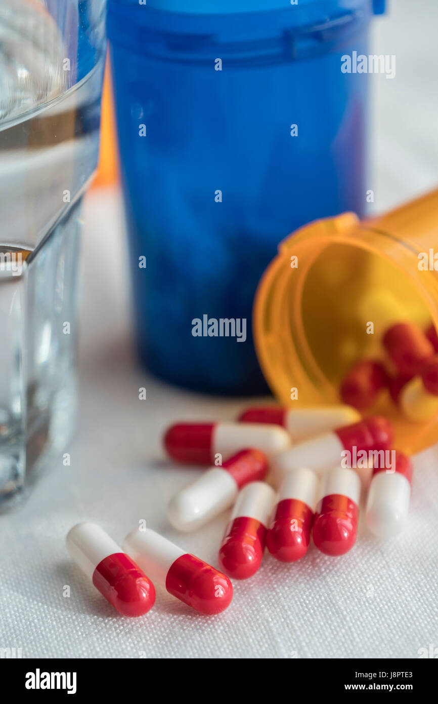 Red and white pills, blue container transparent on background Stock ...