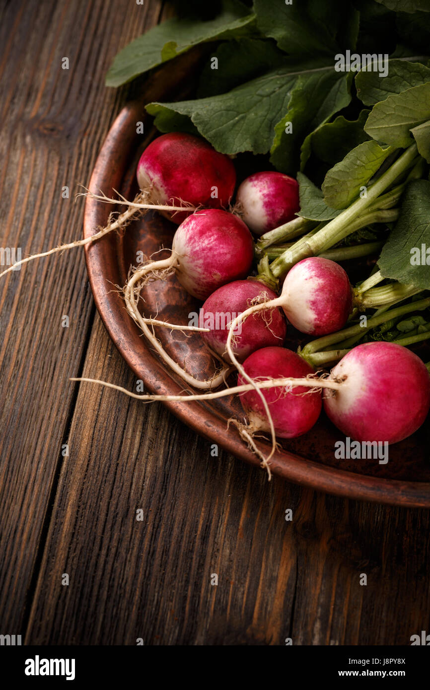 Fresh small red radishes with leaves, rustic style background Stock ...