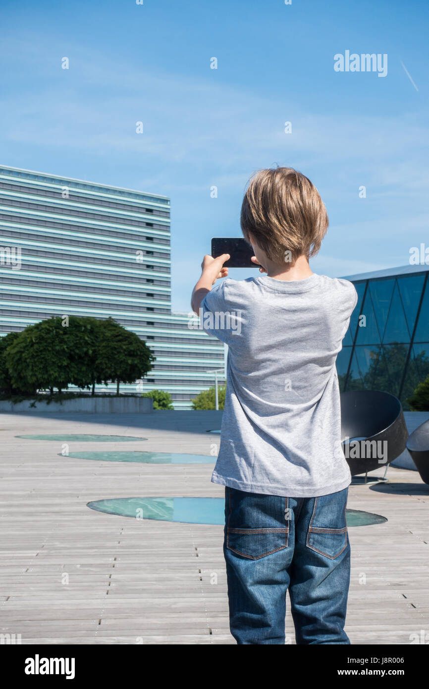 Boy taking photo with his smartphone. Back view Stock Photo - Alamy