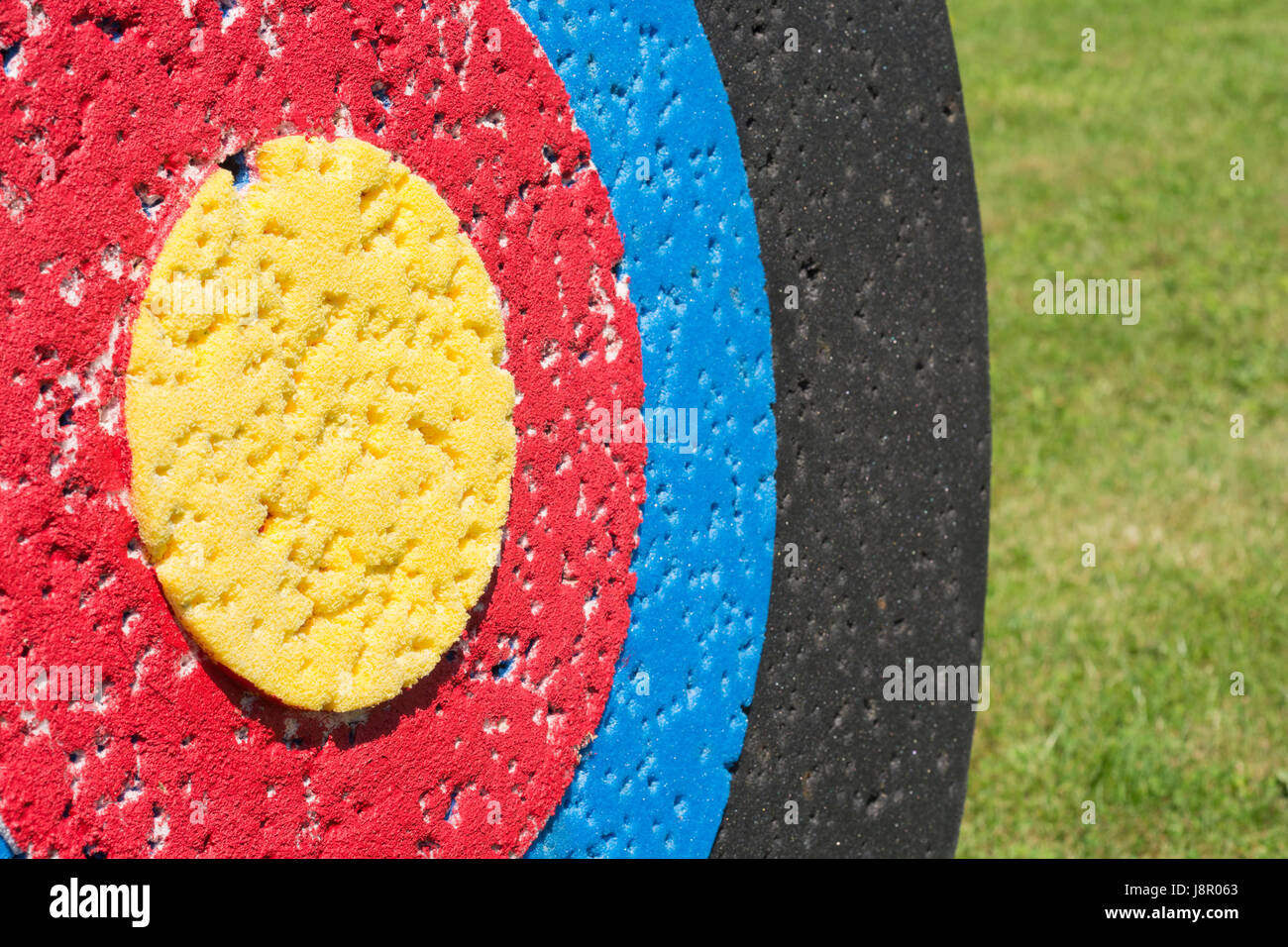 Well-used archery target with yellow bull's-eye, and numerous arrow ...