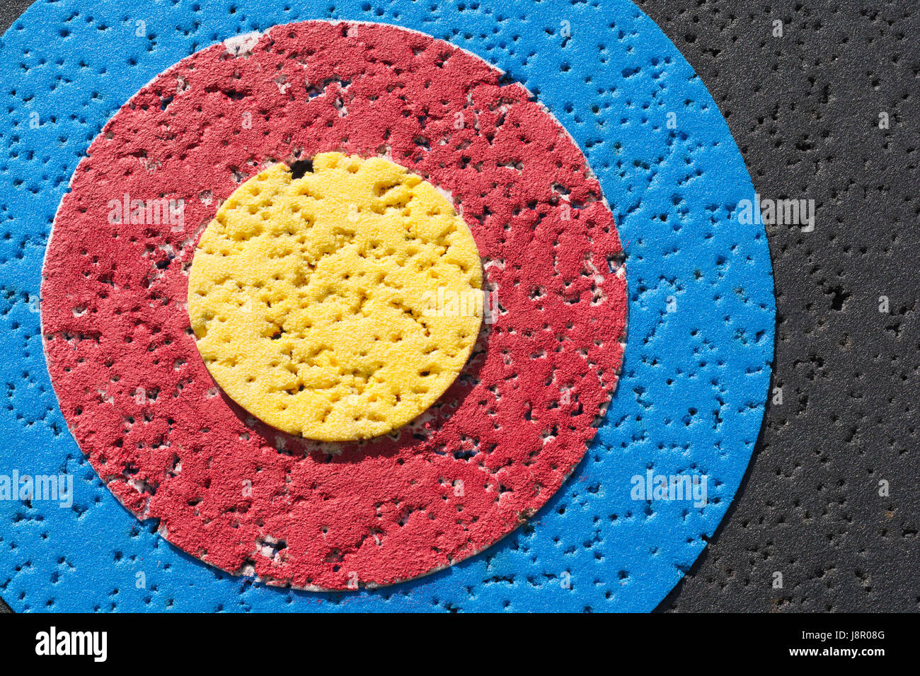 Well-used archery target with yellow bull's-eye, and numerous arrow ...