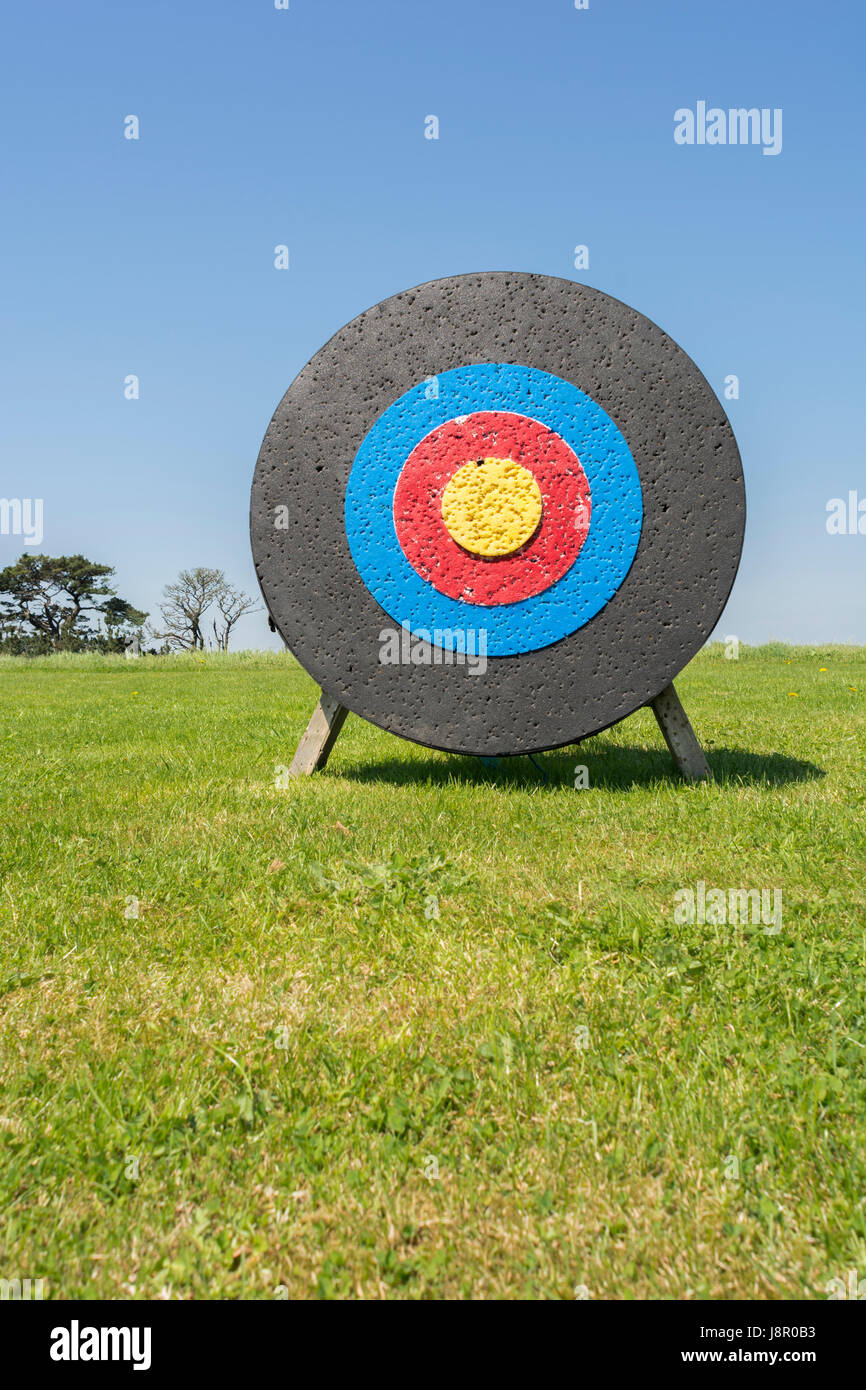 Well-used archery target with yellow bull's-eye, and numerous arrow ...