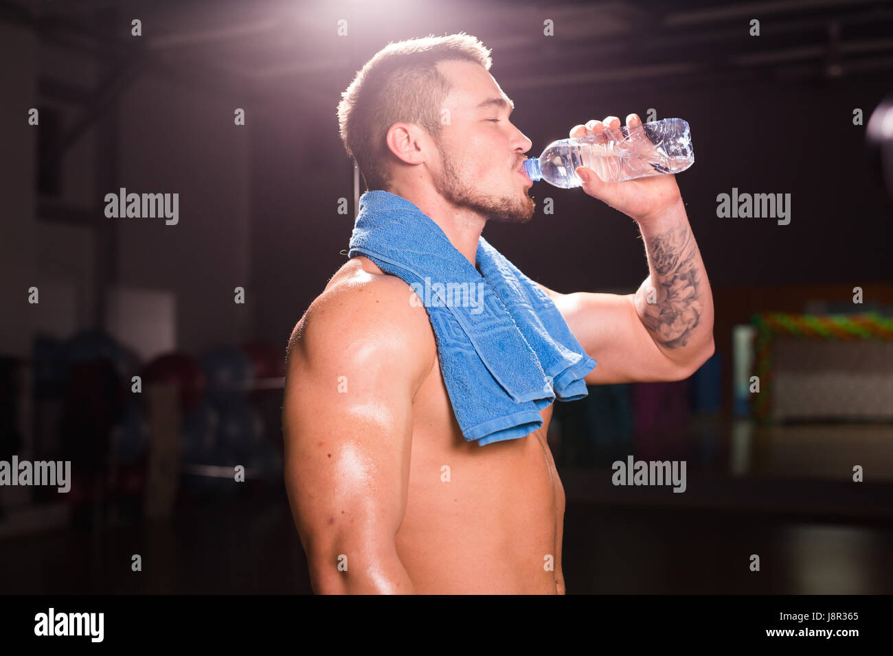 young caucasian bodybuilder in the gym drinking a bottle water Stock ...