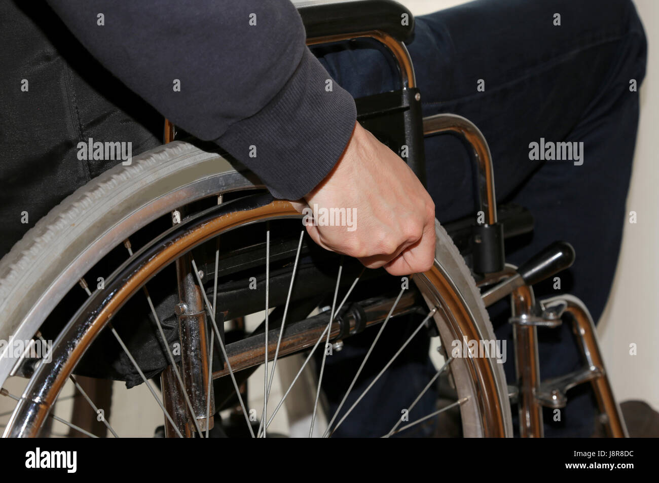 Hand on the wheelchair in the bedroom of the disabled young man Stock ...