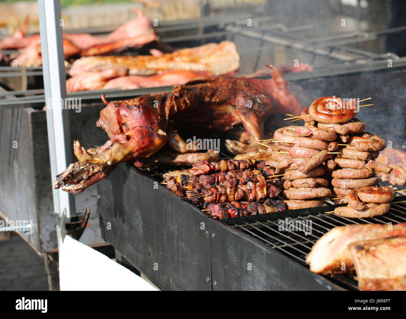 street food stall with a lot of pork and cooked beef and sausages Stock ...