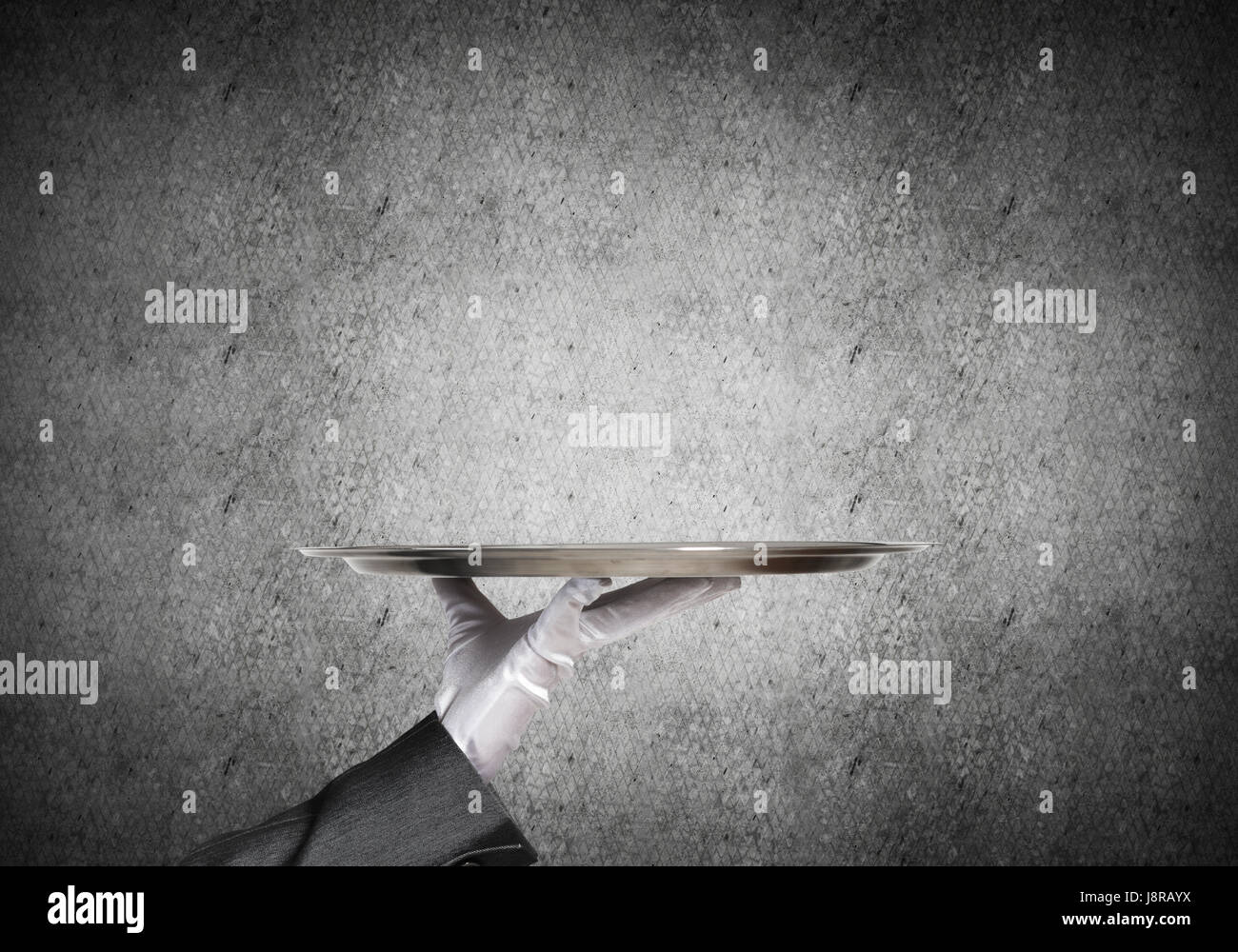Hand of butler holding empty metal tray against concrete background ...