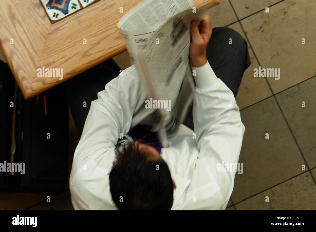 Man reading newspaper view from above Stock Photo - Alamy